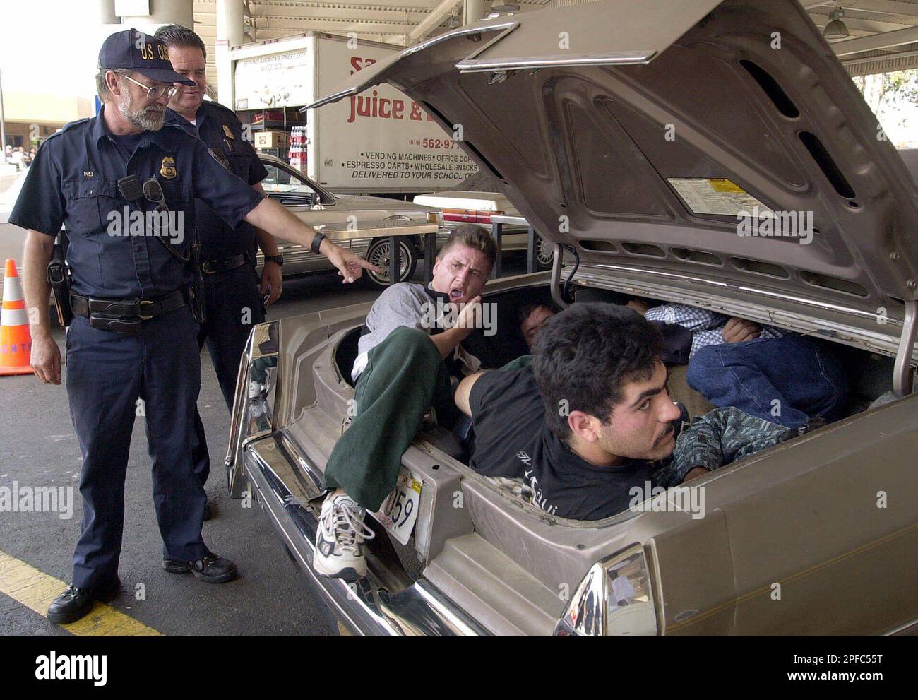 U.S. Customs Service inspectors open the trunk of a car carrying five ...