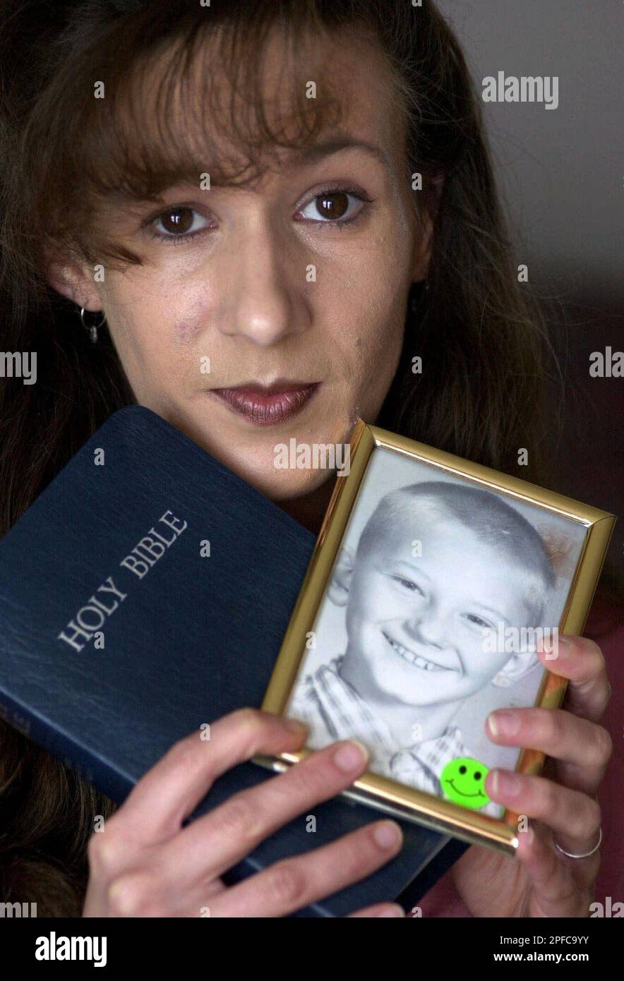 Melanie McCracken displays a picture on May 5, 2000, of Robert Glen Coe as a boy and the Bible ...