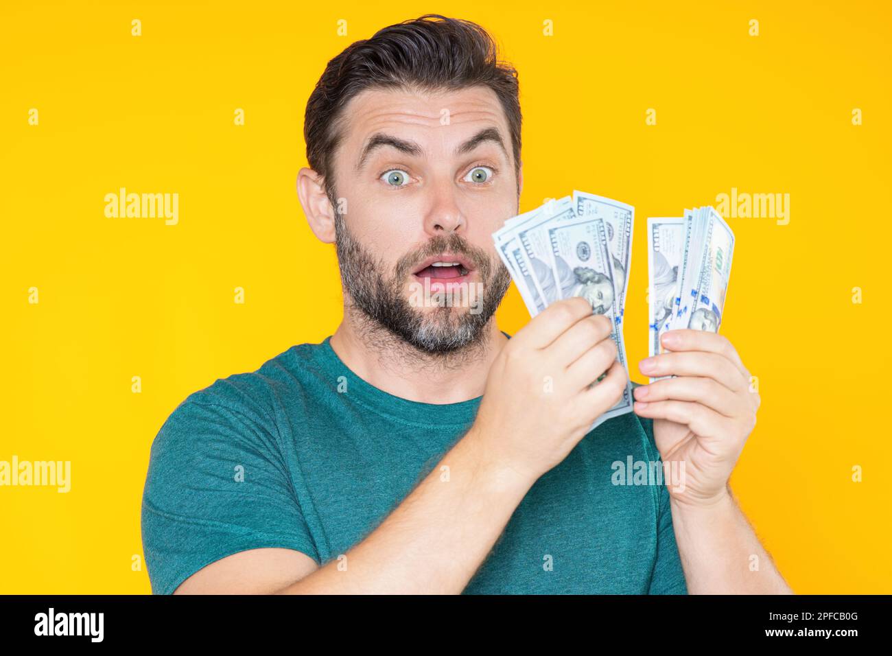 Man holding cash money in dollar banknotes on isolated yellow ...