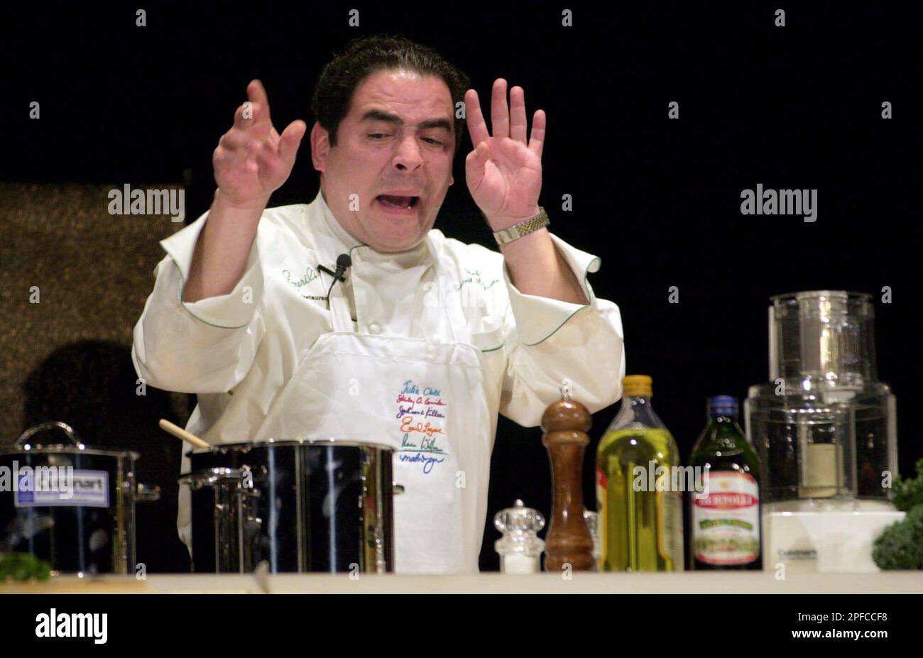 Chef Emeril Lagasse throws spices into a pot of soup with his trademark ...