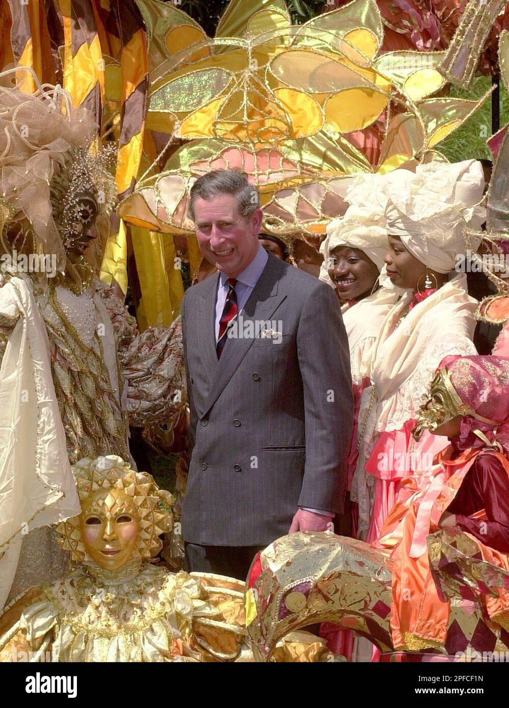 Britain's Prince Charles poses with dancers in carnival costumes while ...