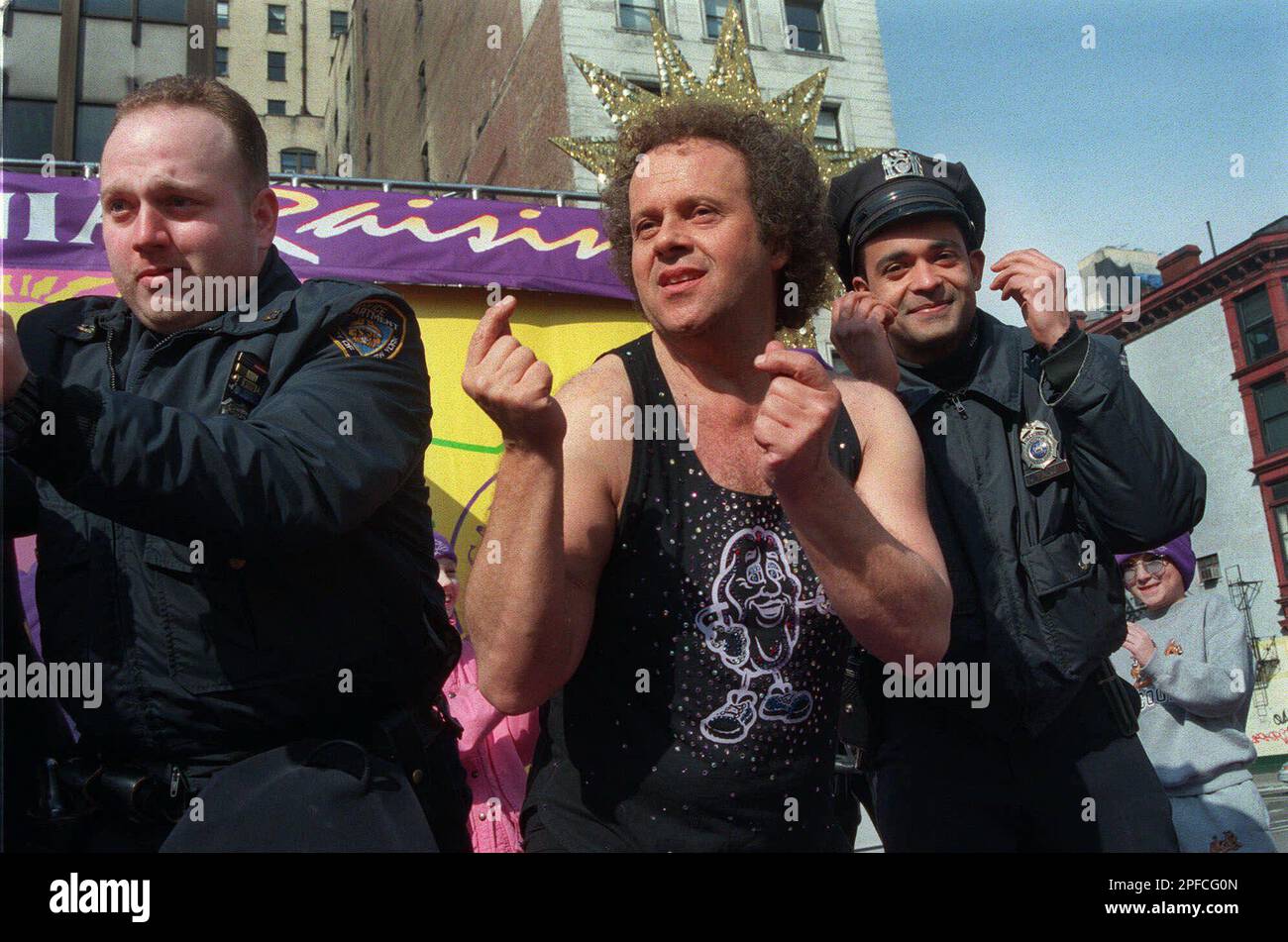 Fitness guru Richard Simmons, center, is joined by New York City police ...