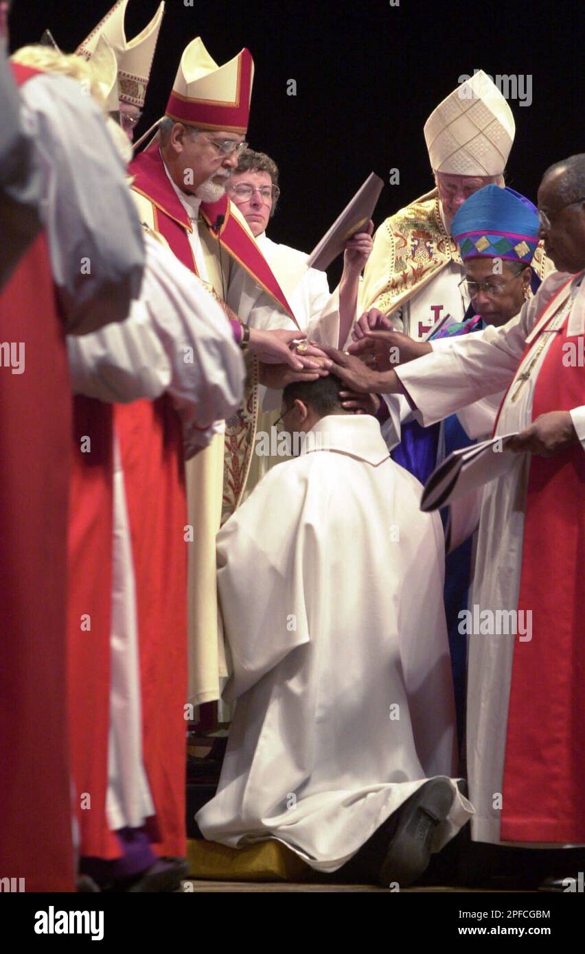 Reverend Wendell Nathaniel Gibbs, kneeling, is touched by consecrators ...