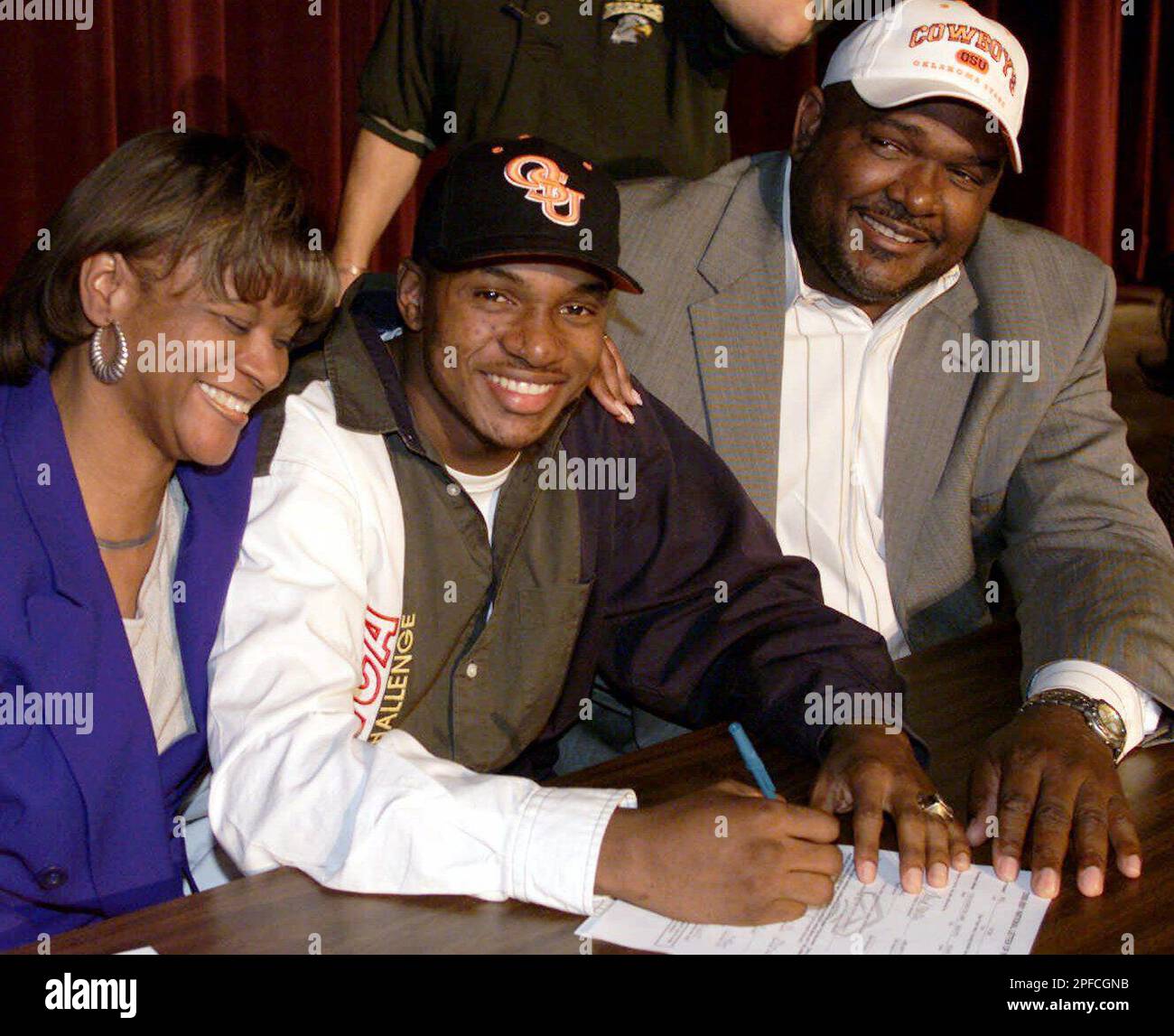 Terry Bell, left, gives her son, Tatum Bell, a DeSoto High School ...