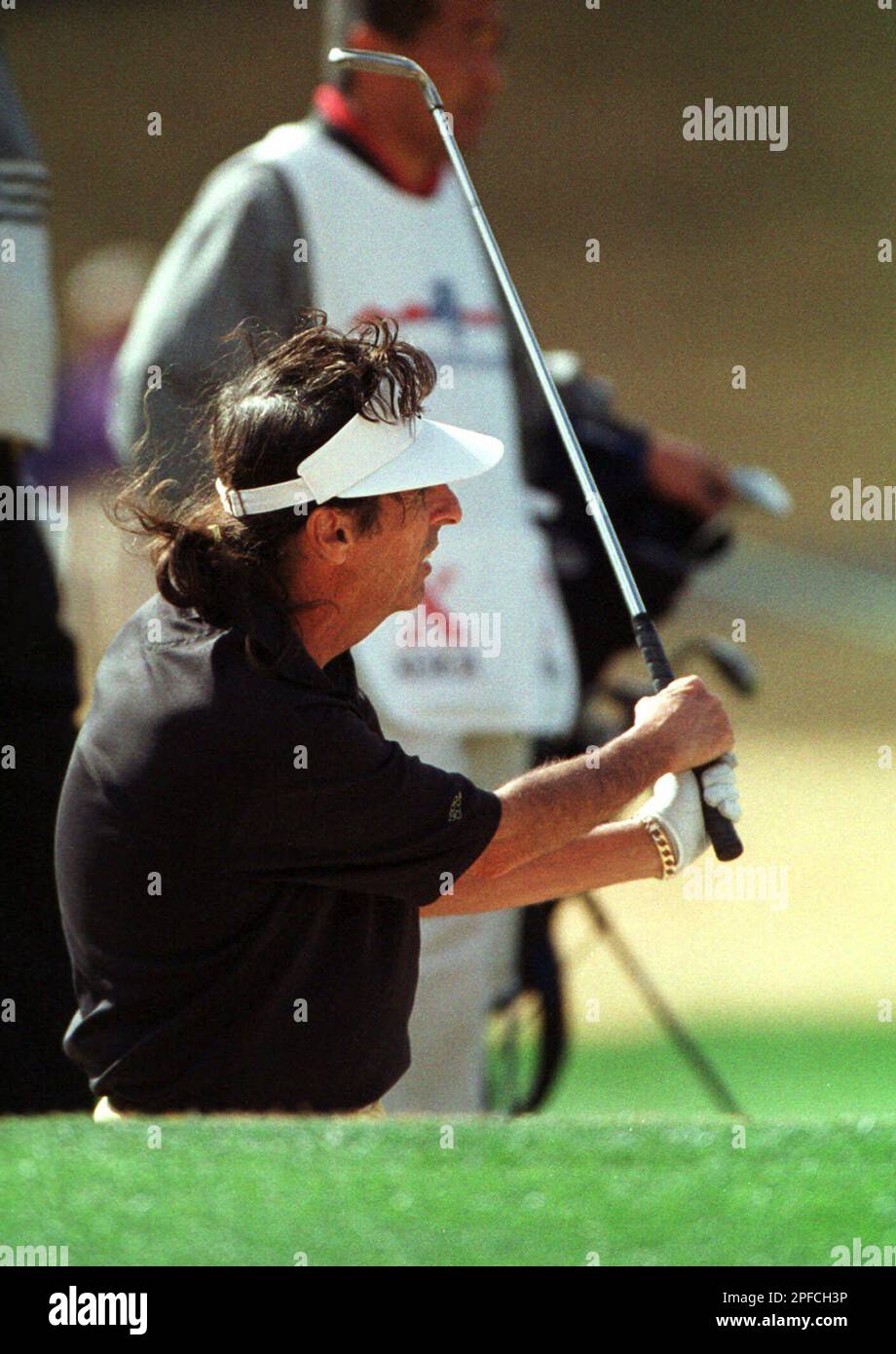 Rock star Alice Cooper watches the flight of his ball as he chips out ...