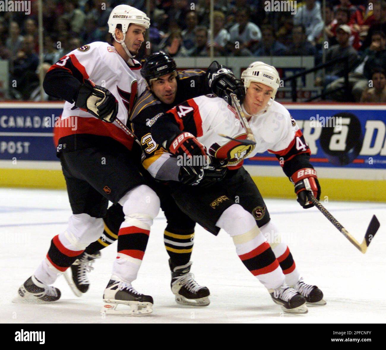 Pittsburgh Penguins' Stephen Leach tries to squeeze by Ottawa Senators ...