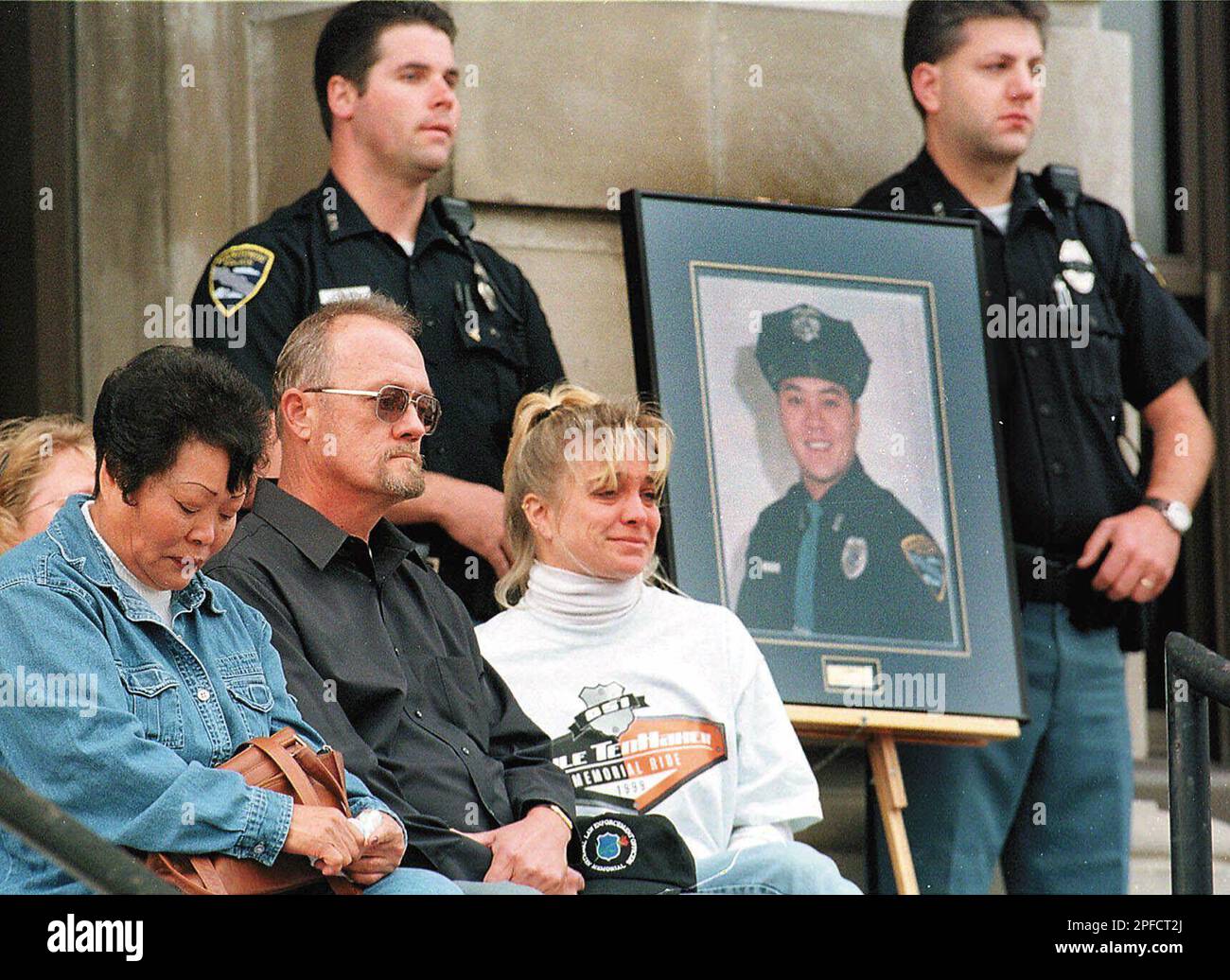 Trying to hold back tears during a memorial service for slain police ...