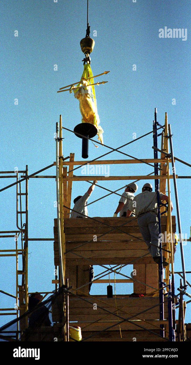 The statue of a rearing horse is lowered into place atop the Colt ...