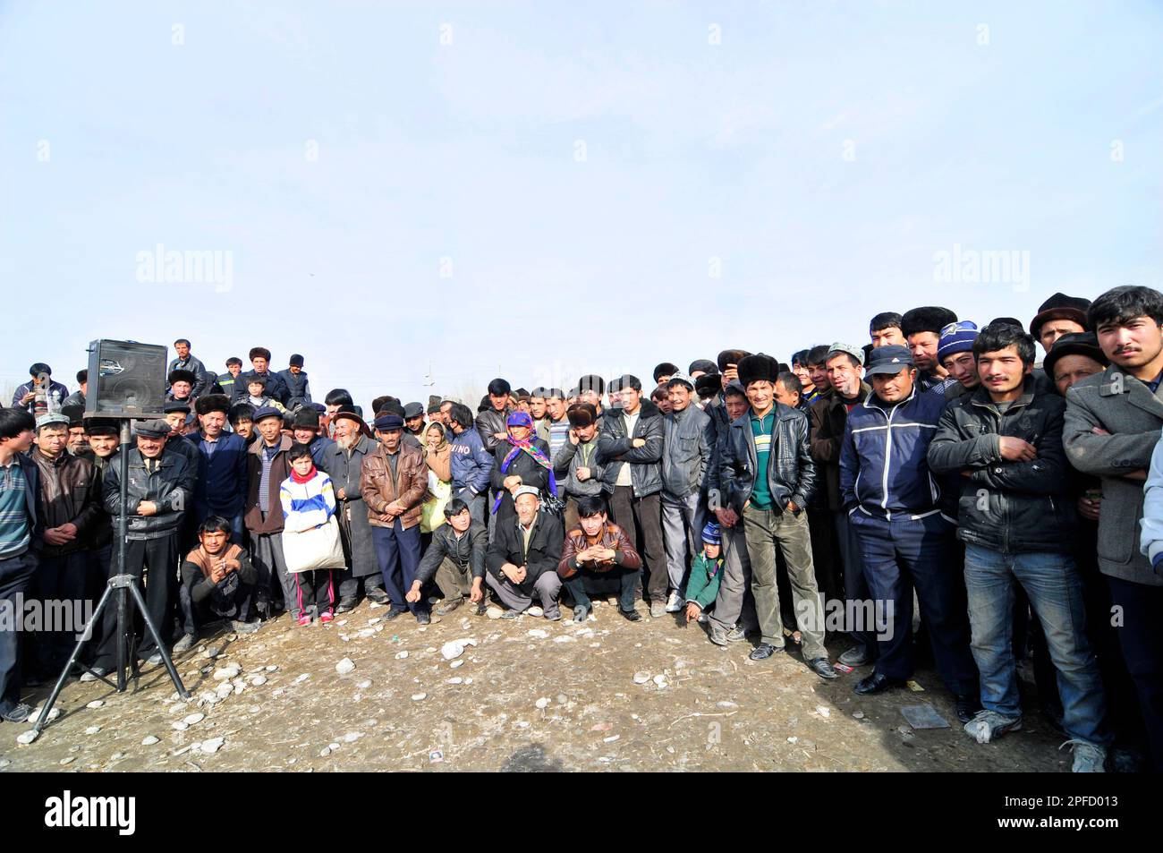 Uyghur men watching a show by a performer at a local weekly market in ...