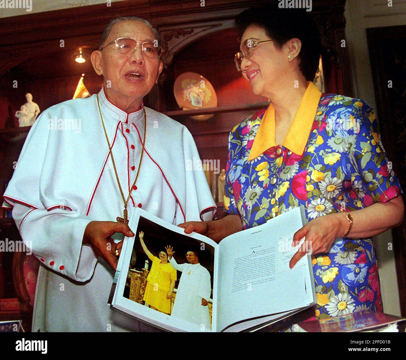 Influential Manila Archbishop Cardinal Jaime Sin, left, shows a page of ...