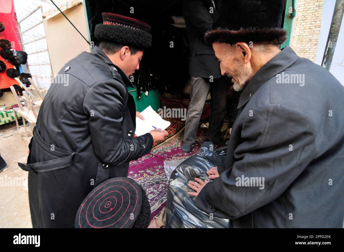 Uyghur men standing outside a workshop in the old city in Kashgar ...