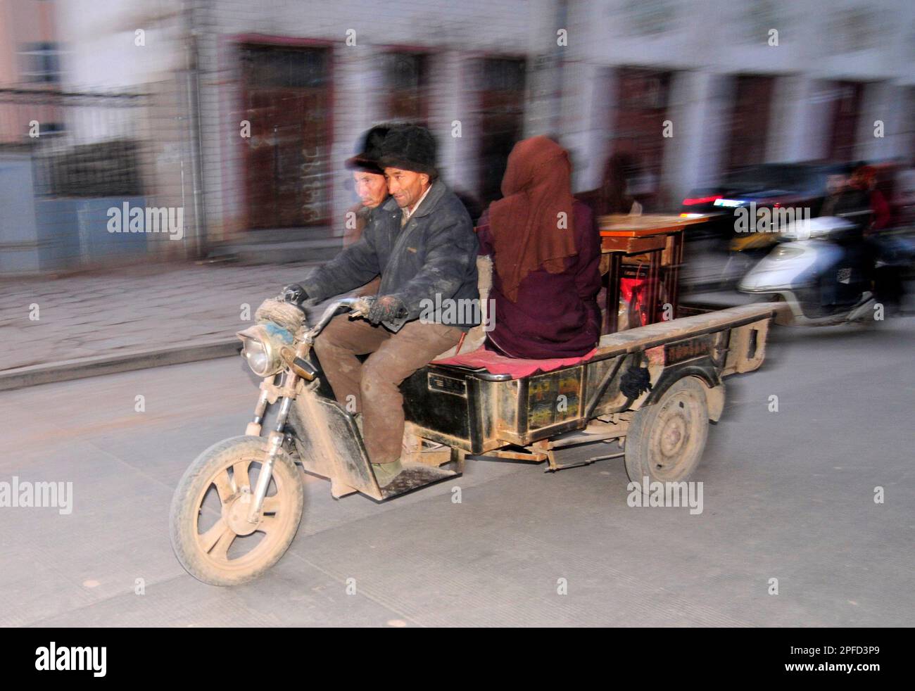 An Uyghur man driving his Motor Tricycle in the old city of Kashgar ...