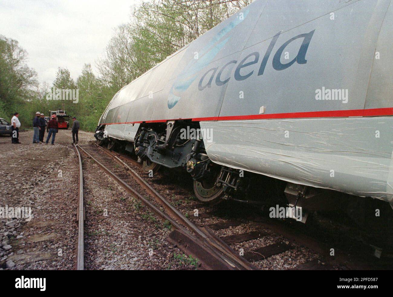 Workers look over the derailed "Acela" engine, Amtrak's new high-speed ...