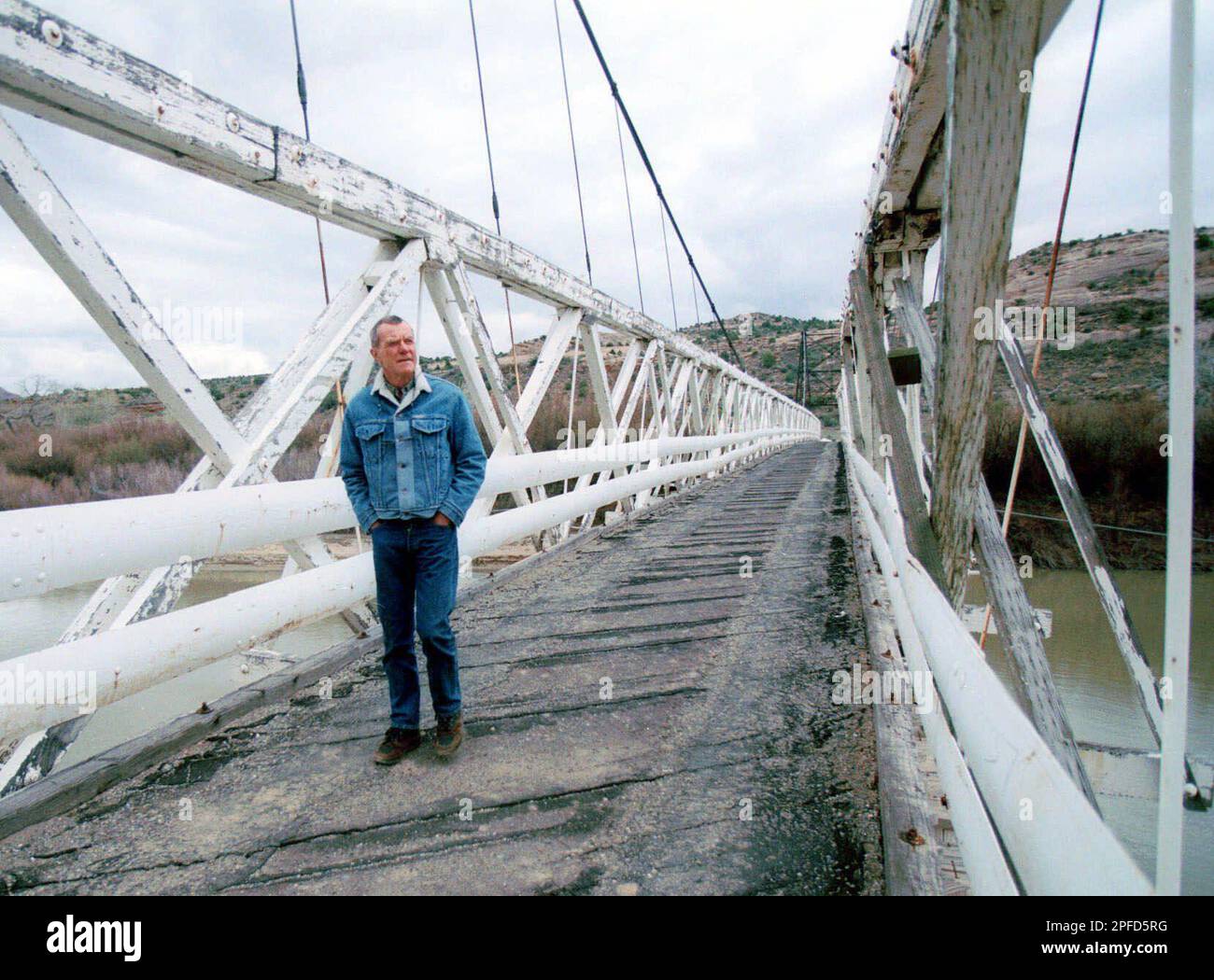 Larry Lunt takes a walk across the historic single lane Dewey Bridge ...