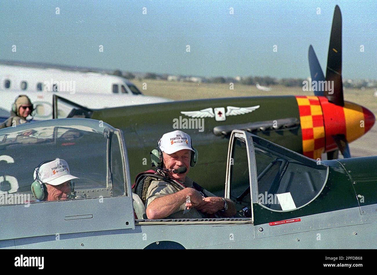 Chuck Yeager, right, straps himself into the cockpit of a vintage P-51 ...