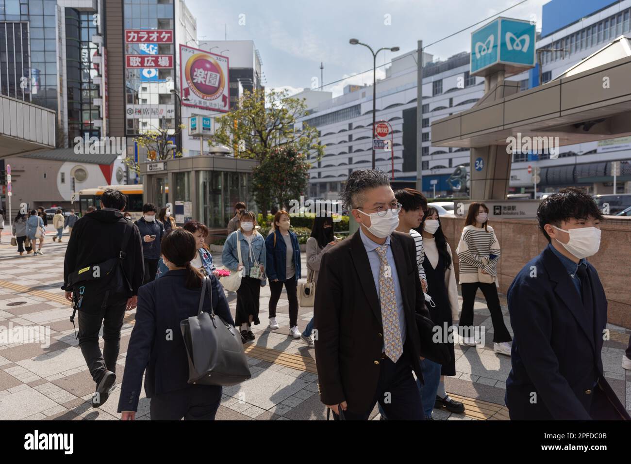 Pedestrians walk in front of Ikebukuro subway station in Tokyo. Japan ...