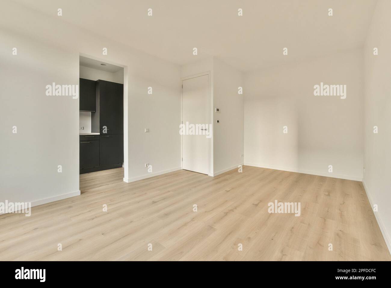 an empty room with white walls and wood flooring on the right, there is ...
