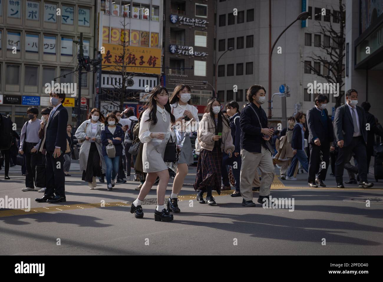 Pedestrians walk towards Shinjuku station in Tokyo. Japan eased COVID ...