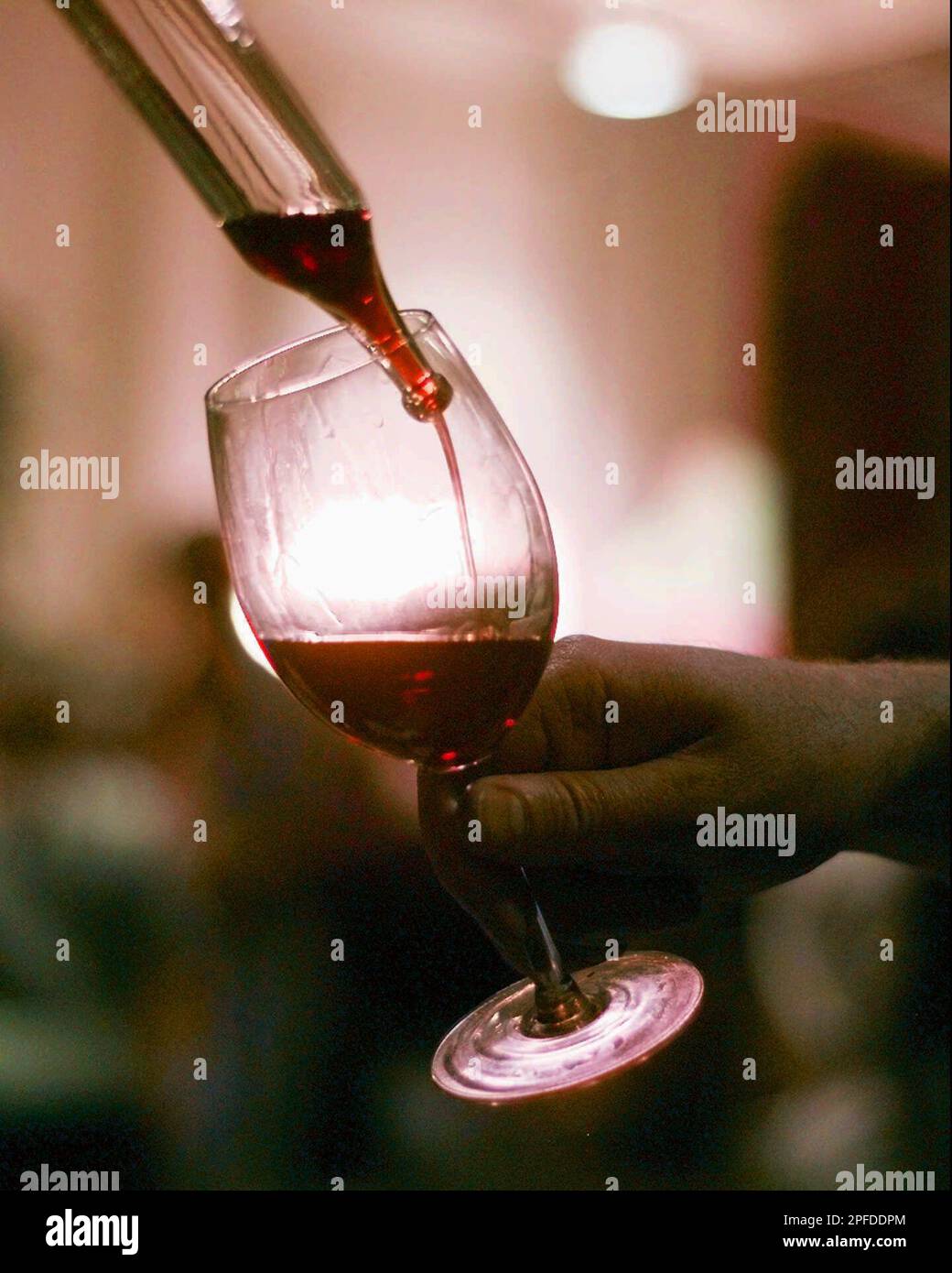 A winemaker with Robert Sinskey winery uses a wine thief to draw a ...