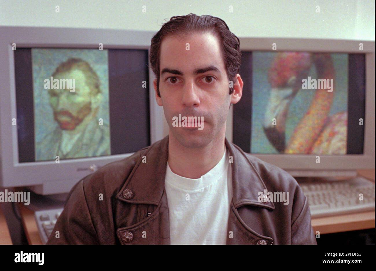 Artist Robert Silvers sits in between two computer screens with ...