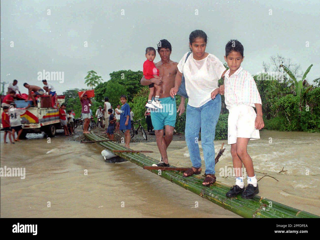 Maritza Cajas crosses a makeshift bridge with her son Jesus Tuesday ...