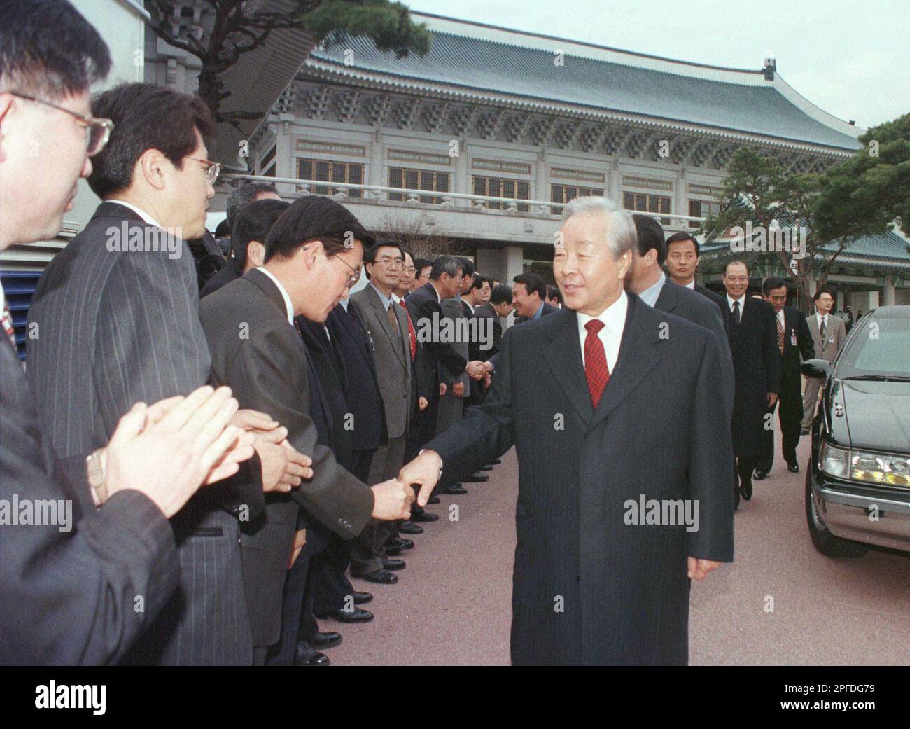 South Korea's outgoing President Kim Young-sam shakes hands with his ...