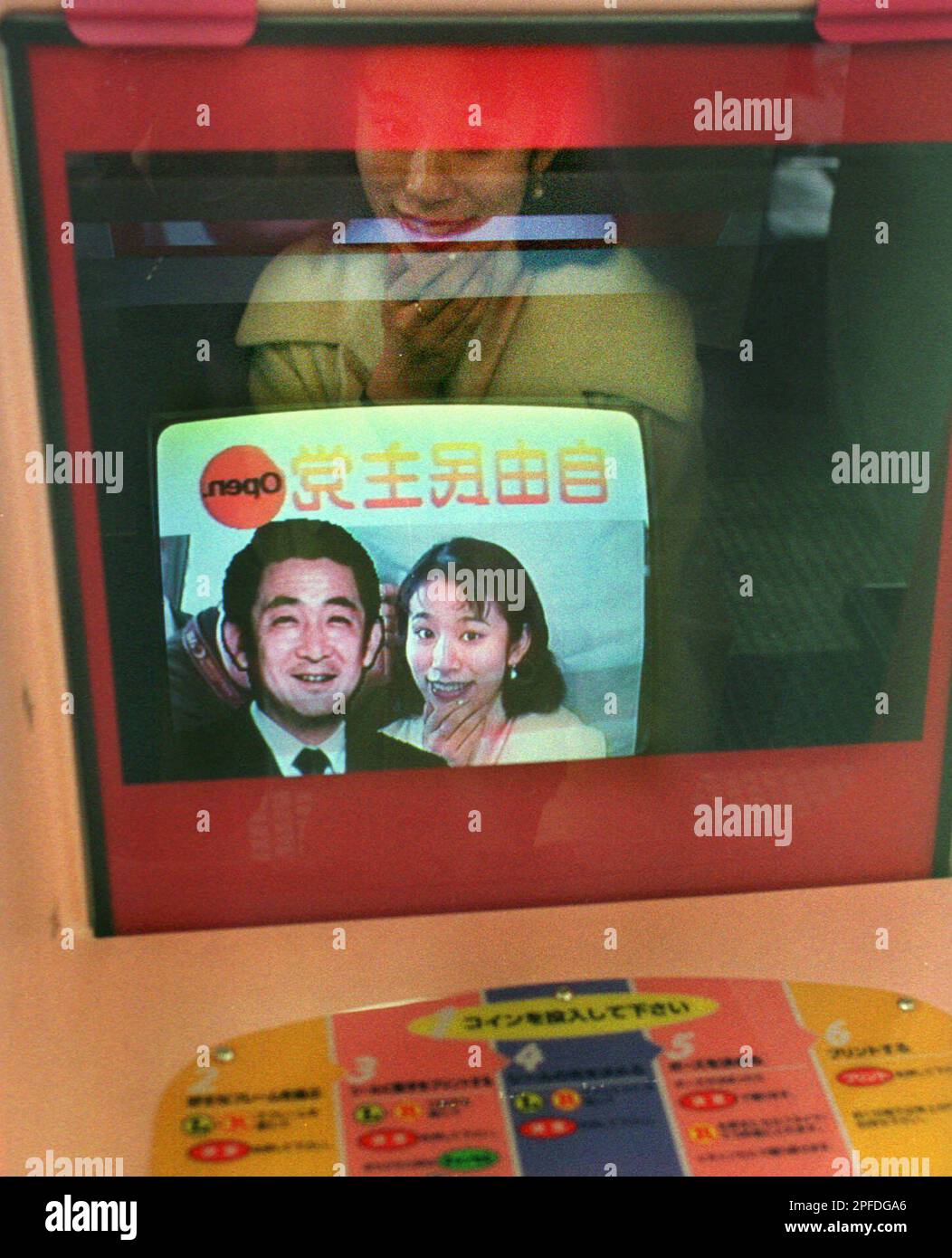 Tokyo student Aiko Komori is reflected on the screen of the "Print Club," an instant photo ...