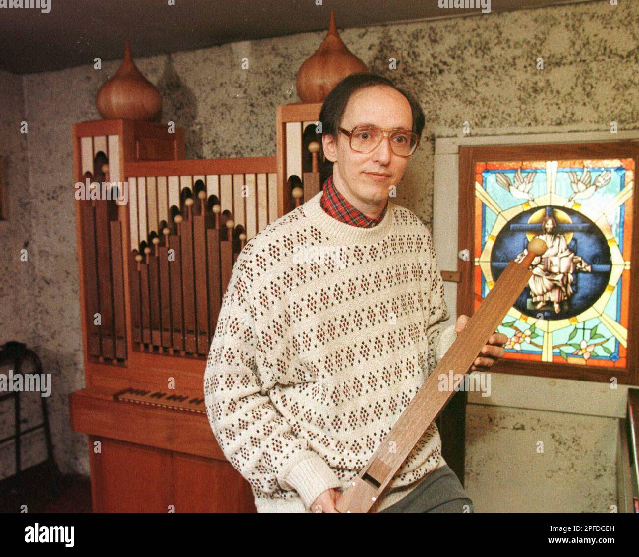 Mark Chartier holds one of 42 wooden pipes in the pipe organ he ...