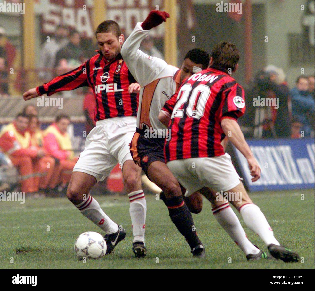 Rome's Paulo Sergio of Brazil, center, is caught between A.C. Milan ...