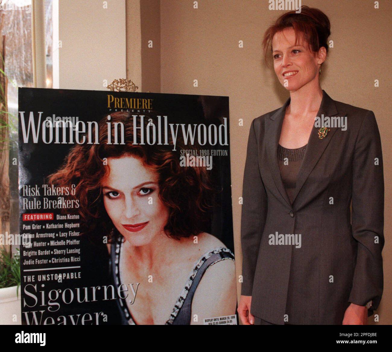 Actress Sigourney Weaver stands next to a poster depicting her cover of ...