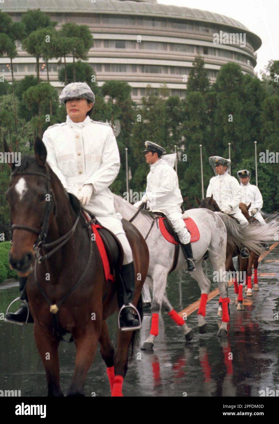 Under pouring rains Kyoto mounted police officers patrol around the ...