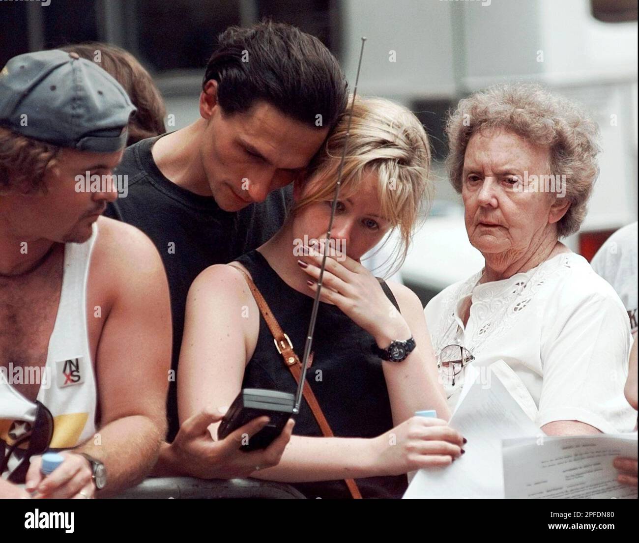 A couple watch a small portable television outside a Sydney church ...