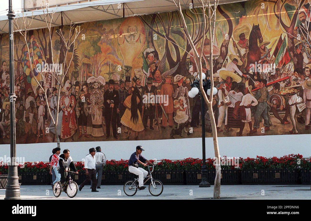 People pass in front of a replica of a famous Diego Rivera mural ...