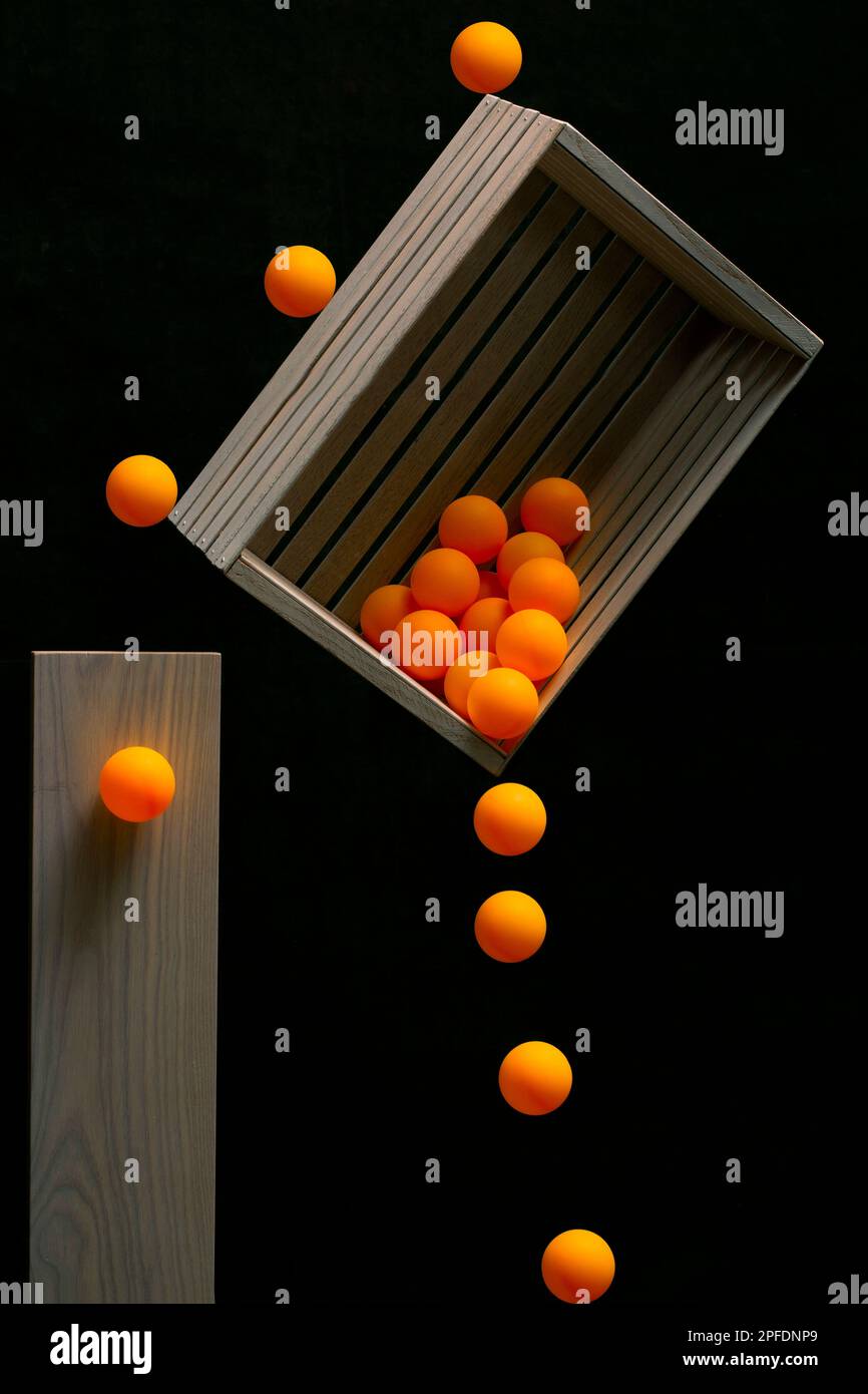 Still life with a wooden box and falling balls Stock Photo - Alamy