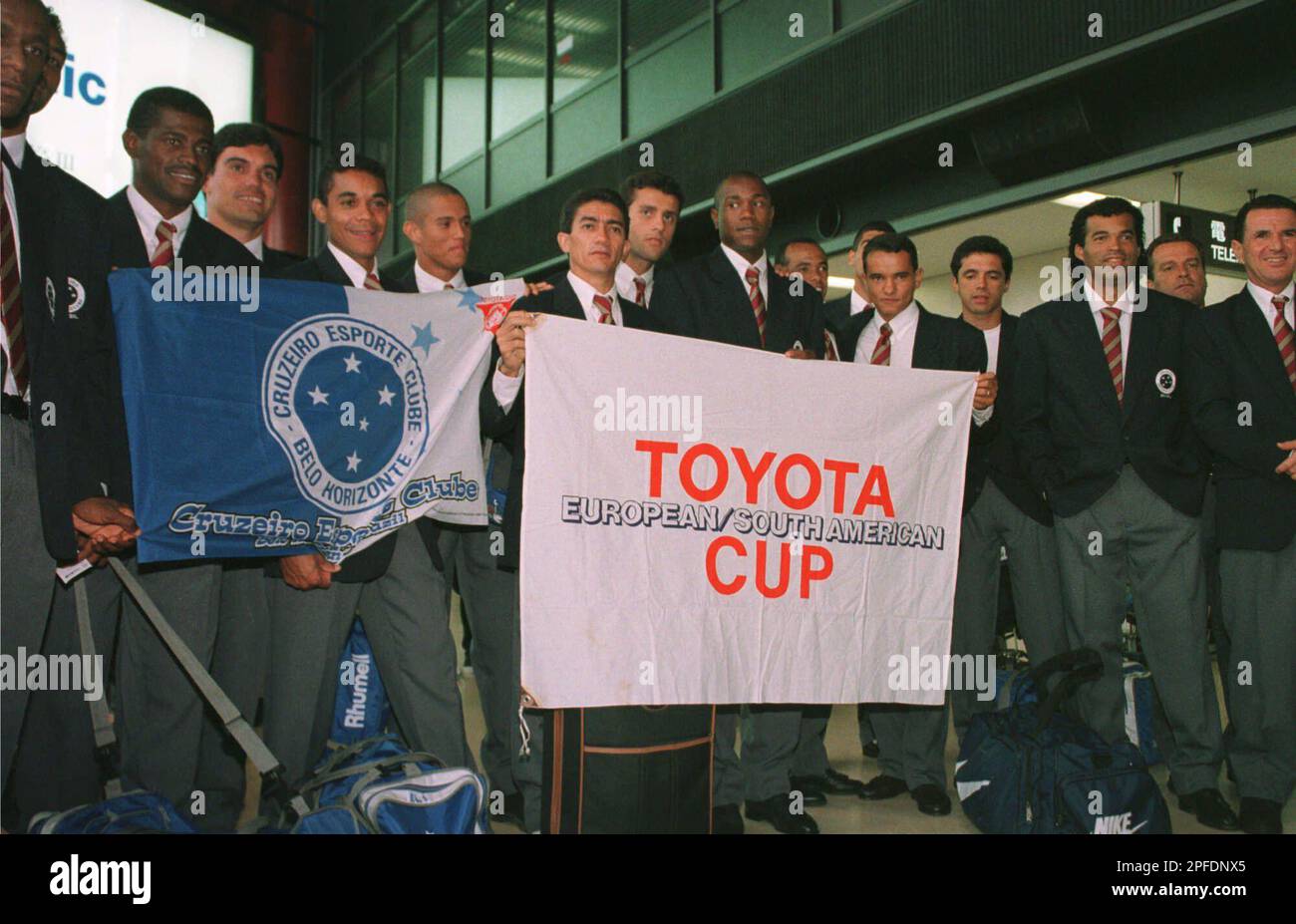 Members of Brazilian soccer team Cruzeiro hold flags of Toyota Cup and ...