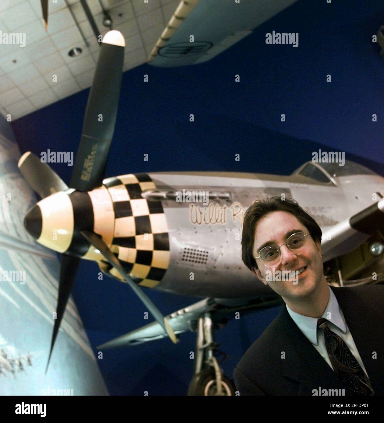 Andrew Chaikin stands under a P-51 Mustang on display at the ...