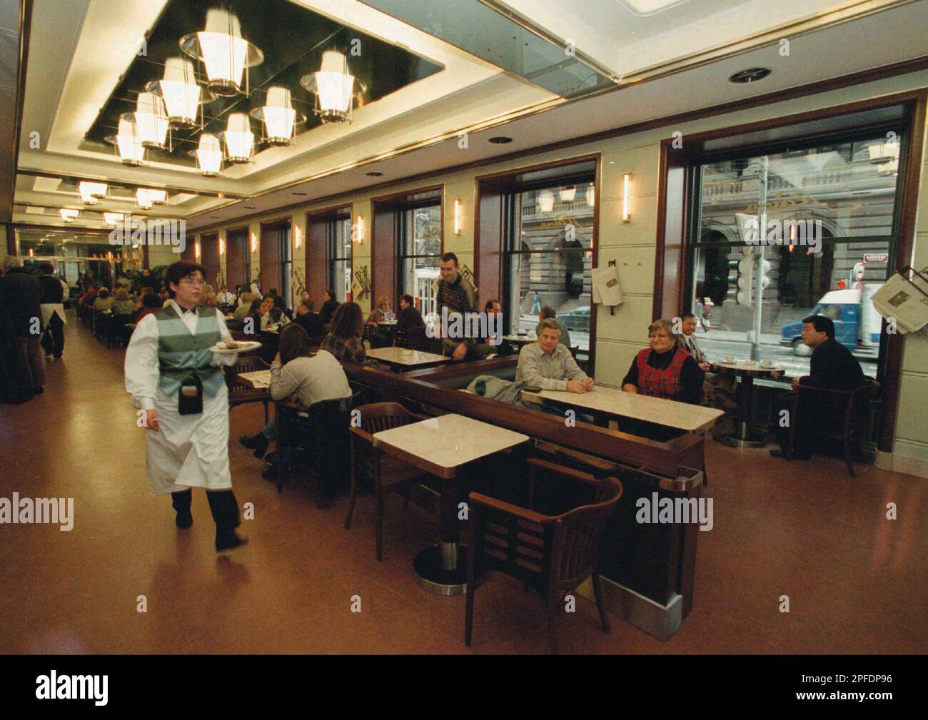 The waiter of legendary Prague's Cafe Slavia serves drinks to the ...