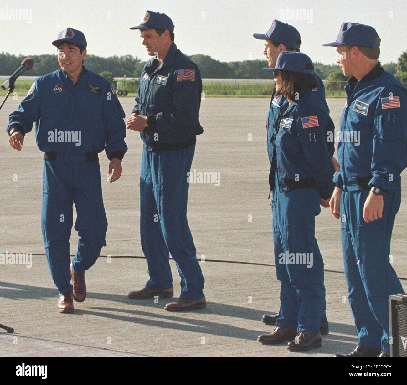 Mission Specialist Takao Doi, left, approaches the mike as crewmembers ...