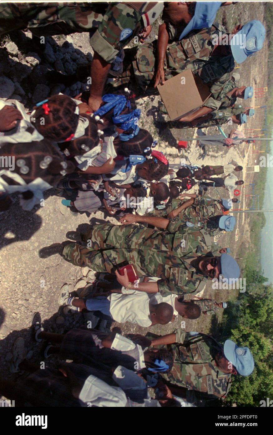Pakistani UN Peacekeepers in Haiti give out packets of dried fruit to ...