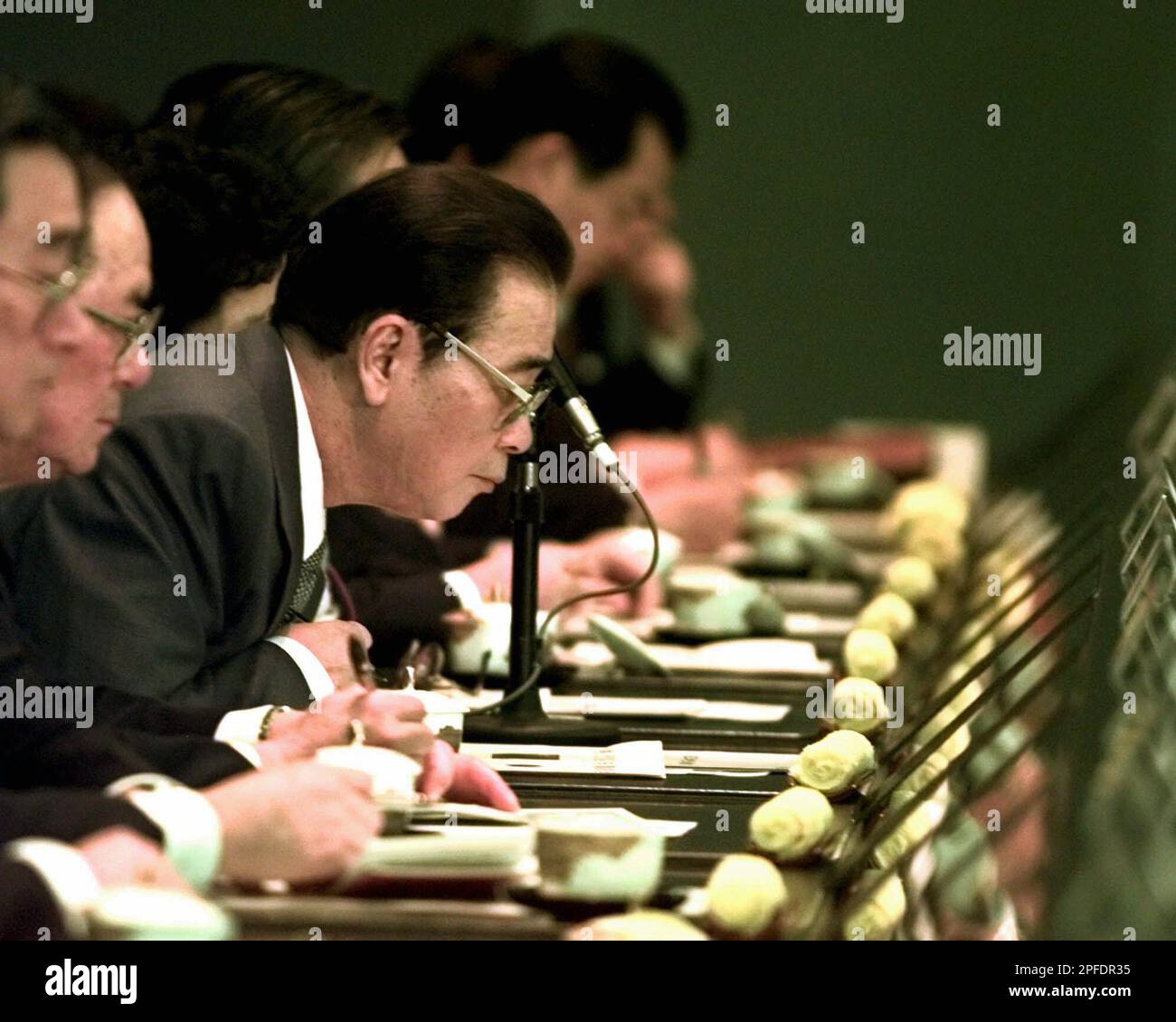 Chinese Premier Li Peng leans forward to take a close look at a ...