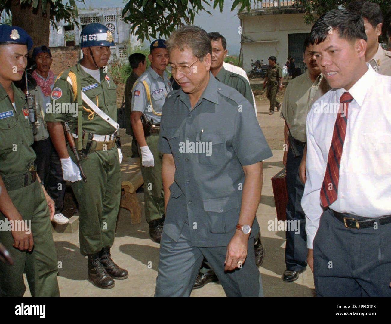 Cambodian First Prime Minister Ung Huot, center, and Pailin Governor Y Chhean, right, walk past ...