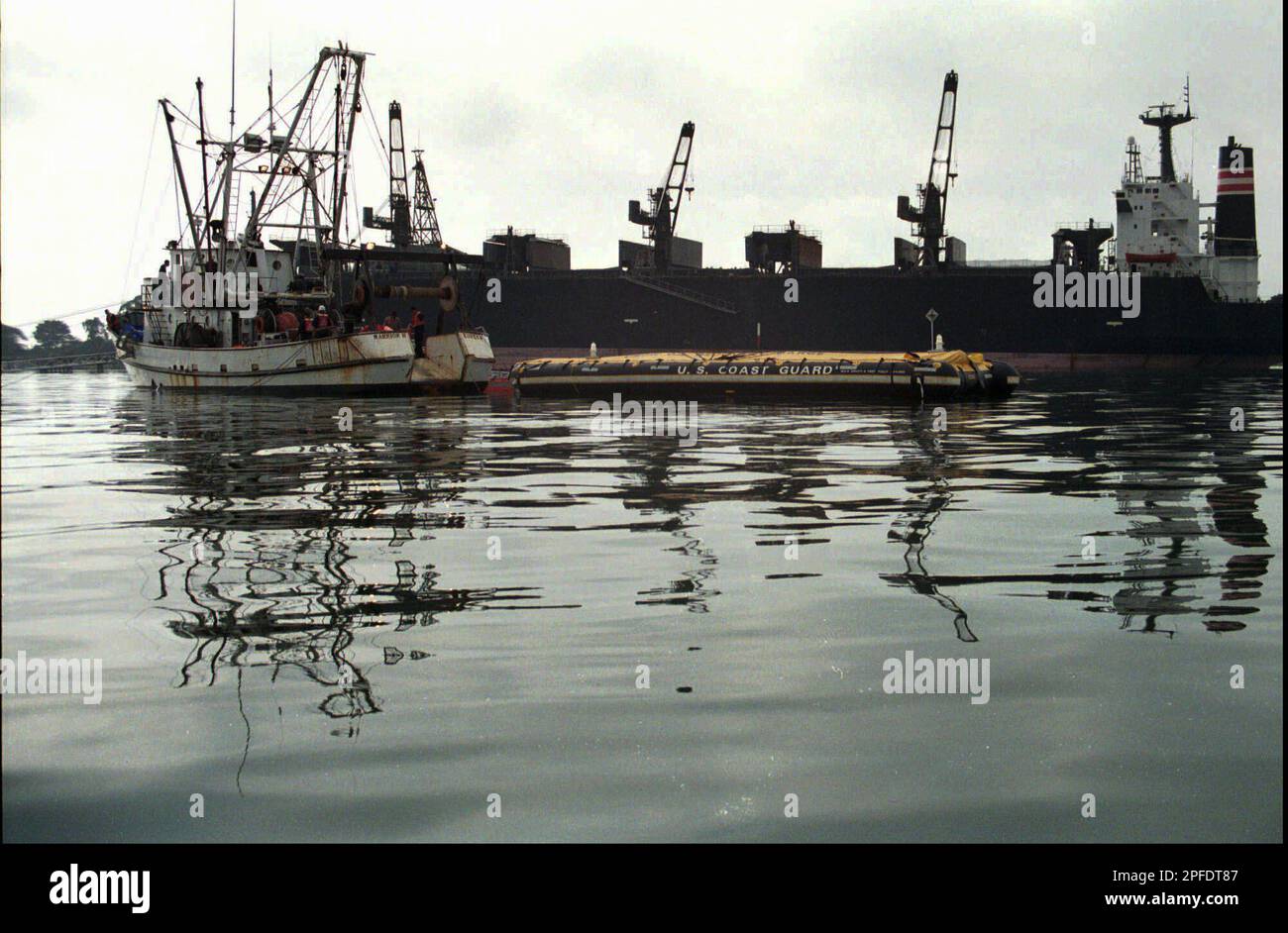 A fishing boat with a U.S. Coast Guard crew aboard skims bunker fuel ...