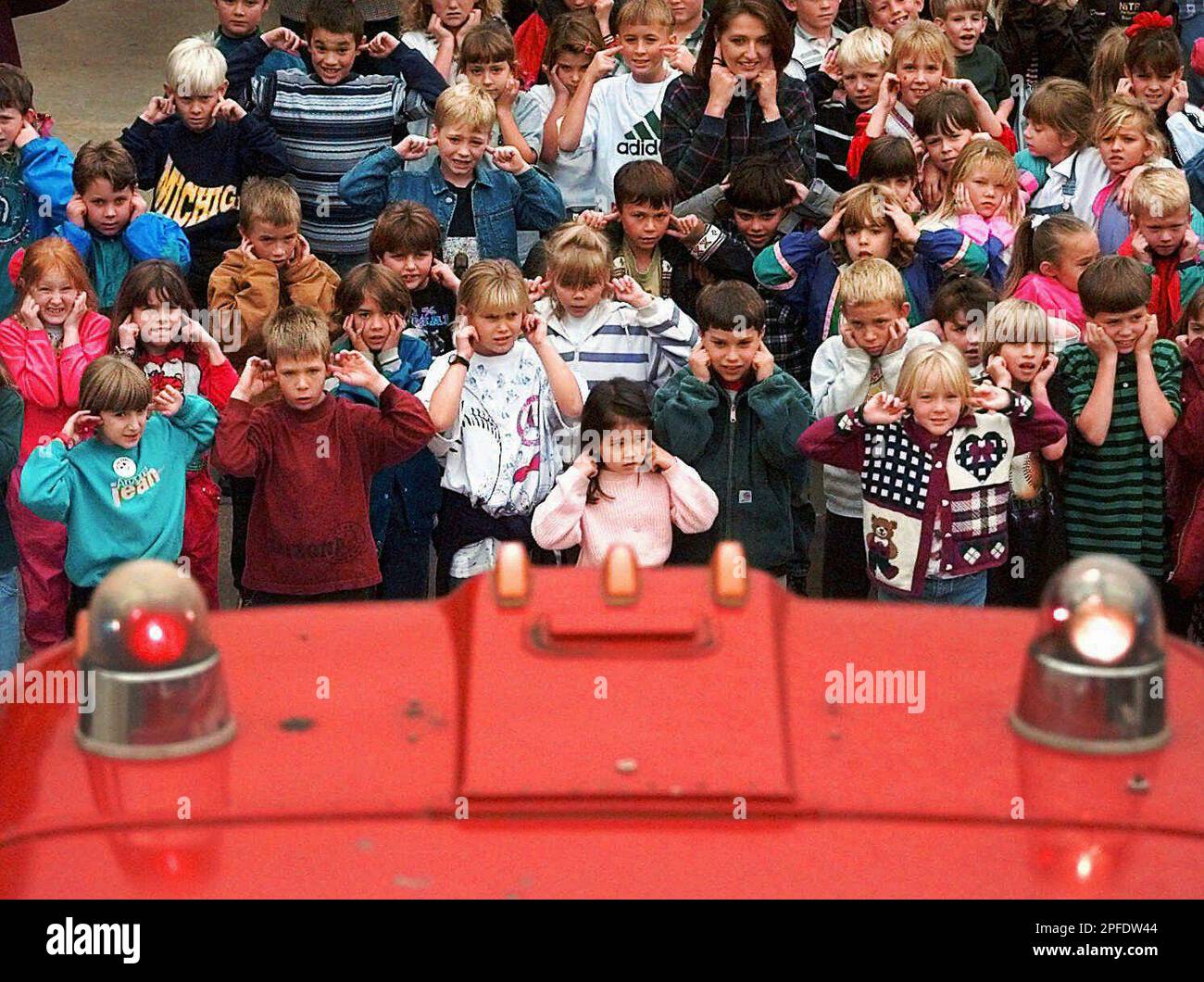 Second graders from Chelsea, Okla., cover their ears as a fire truck ...