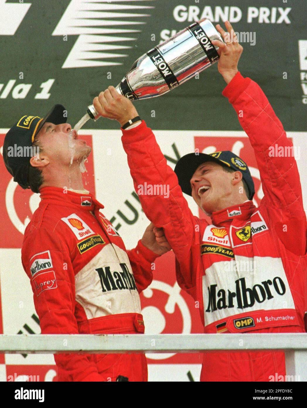 Germany's Michael Schumacher gives his Ferrari teammate Eddie Irvine, who finished third, a ...