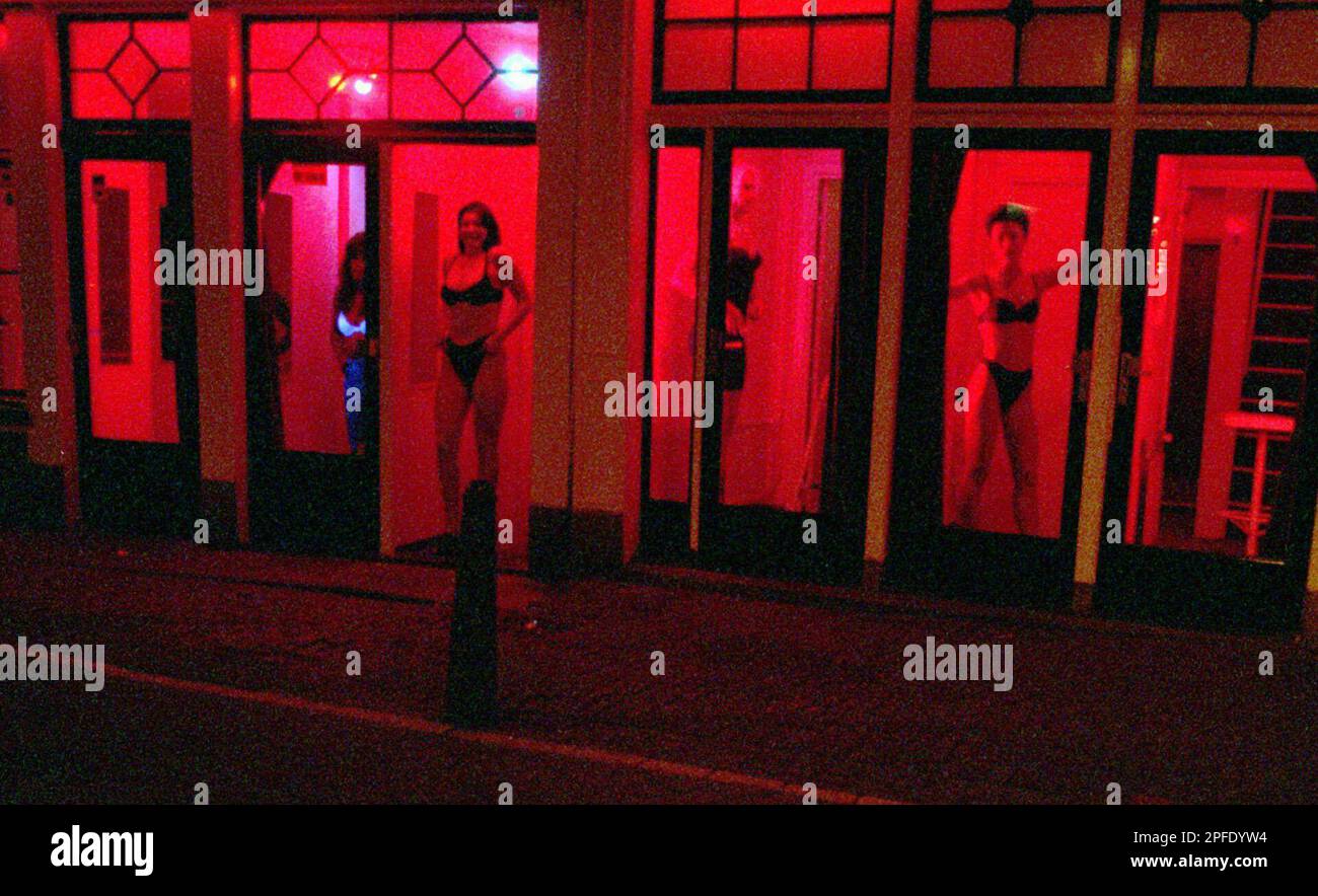 FILE-Prostitutes stand behind red-lit windows, waiting for customers in ...
