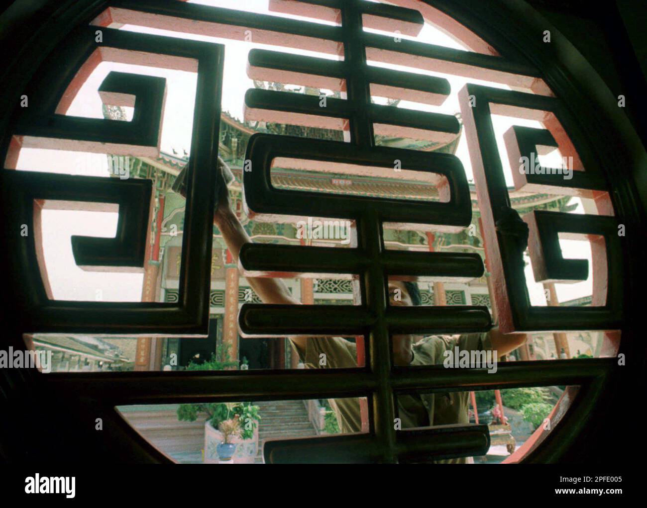 A worker cleans a window of a Chinese temple Pot Man in Bangkok Friday ...