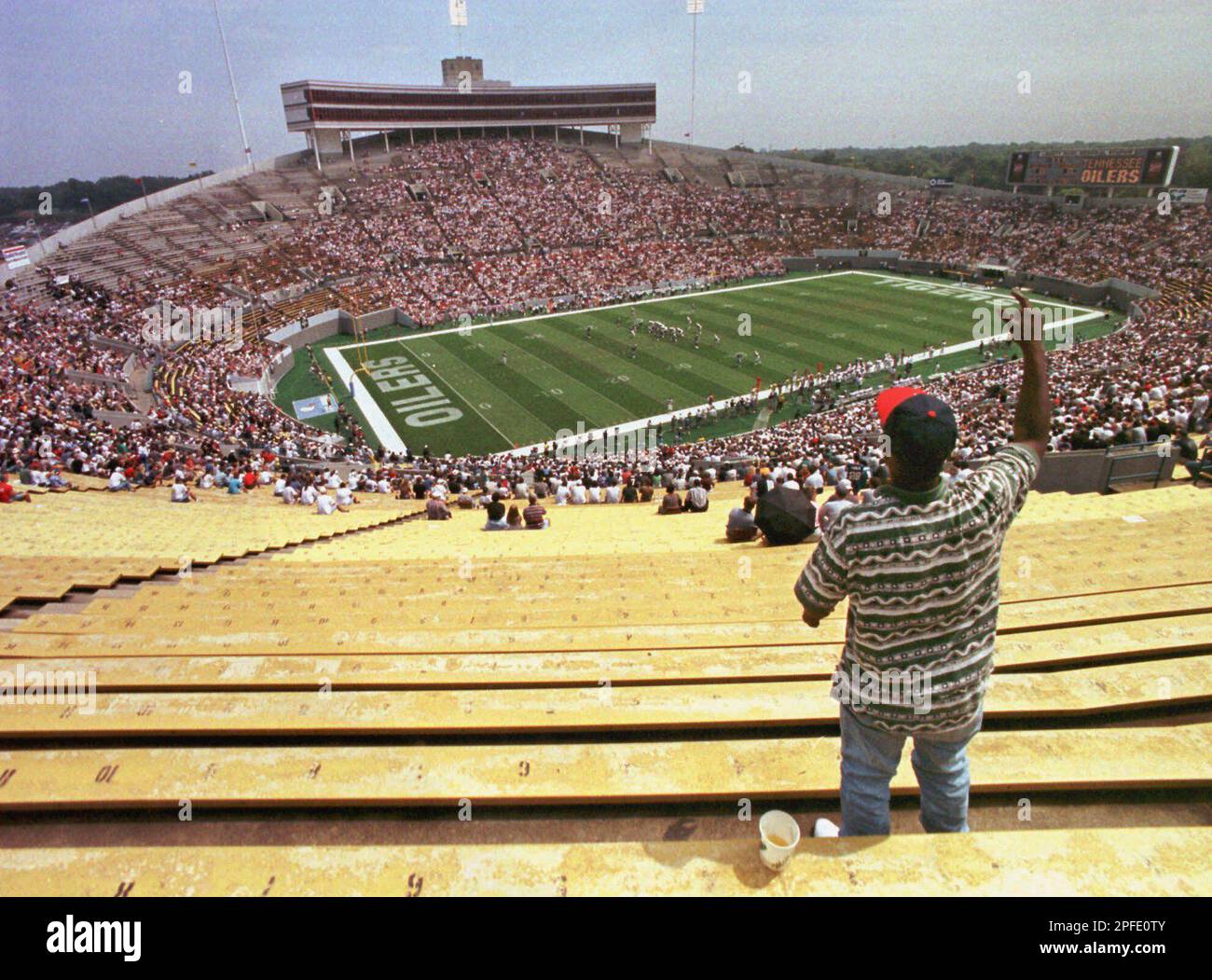 A lone fan surrounded by empty seats cheers on the Tennessee Oilers at ...