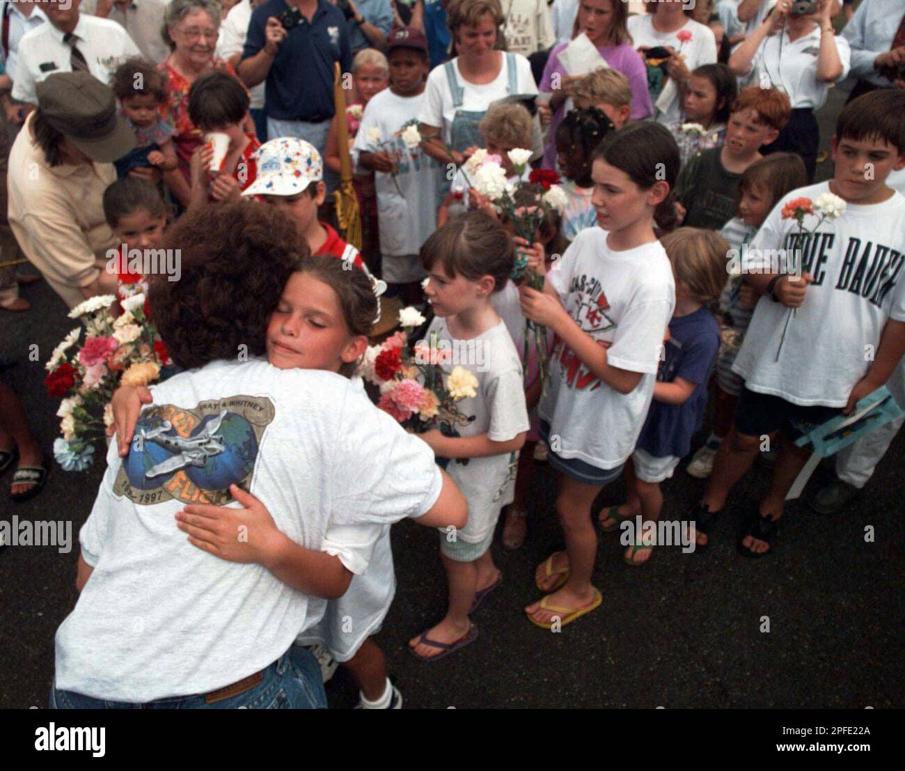 School children gather around aviator Linda Finch to give her flowers ...