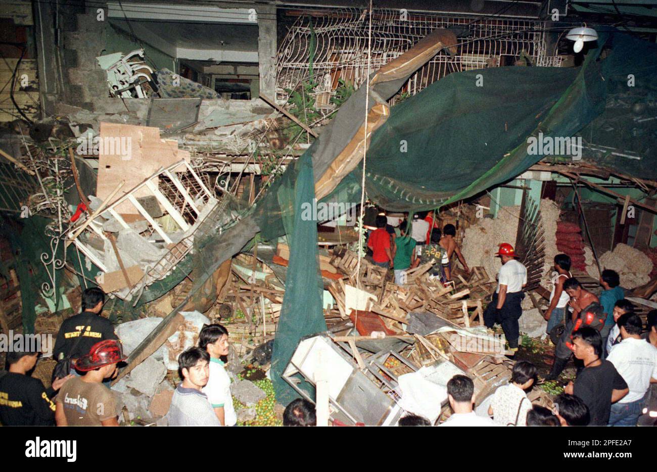 Rescuers and onlookers sift through the debris of vegetable repacking ...