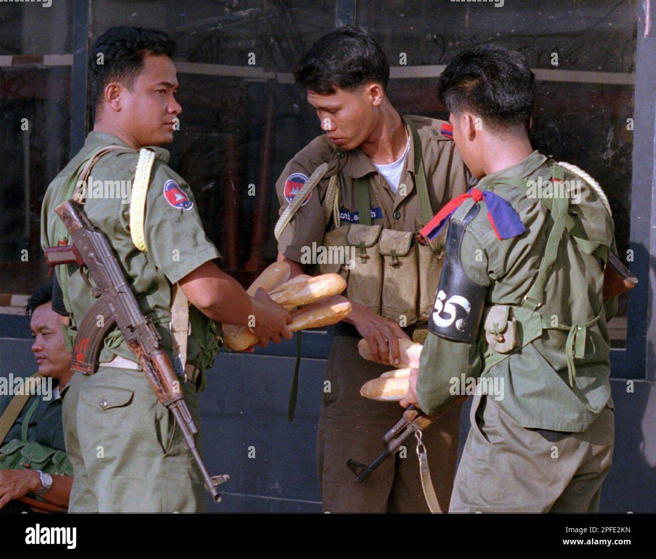 Cambodian government soldiers have a snack while taking a break from ...